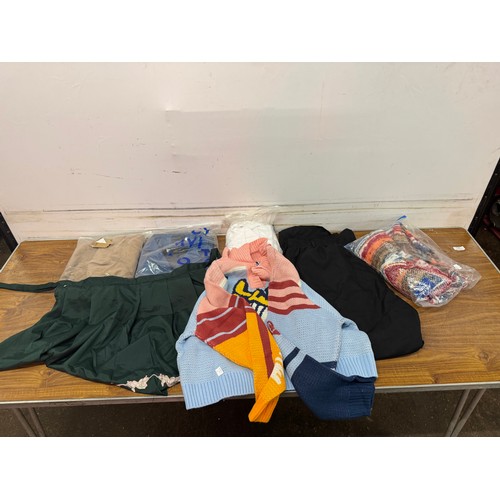 A Large Red parcel bag full of mixed misc. clothing