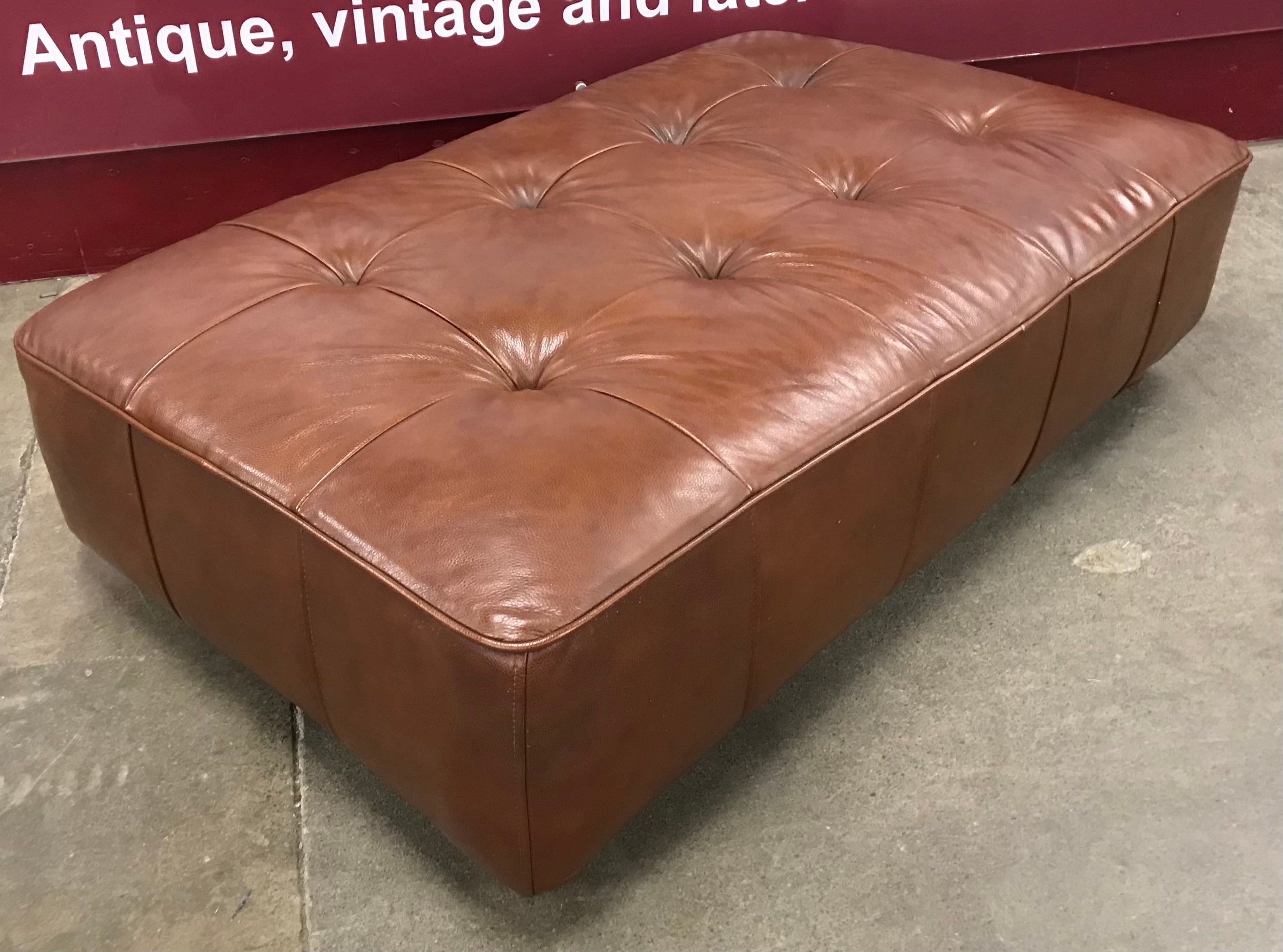 A chestnut brown leather Chesterfield pouffe