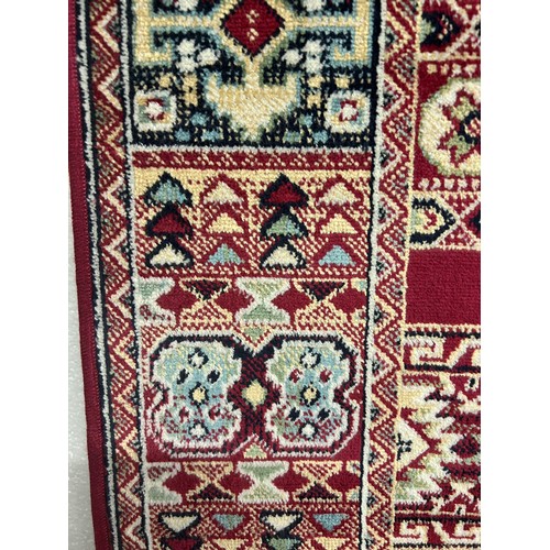 A red ground runner with Aztec design