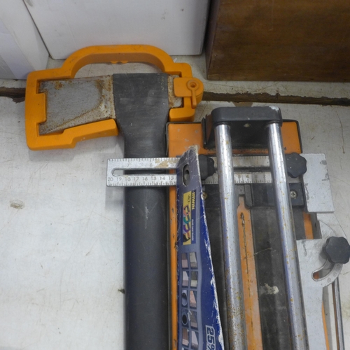 A manual tile saw, a Fiskars X27 axe and an Irwin universal plus 880 saw