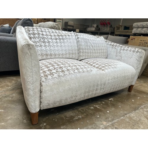 A patterned velvet 2 seater sofa