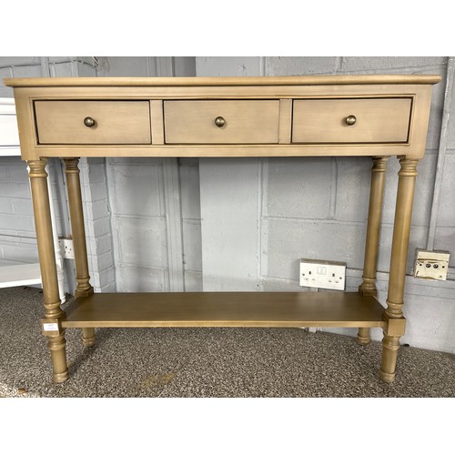A lightwood three drawer console table