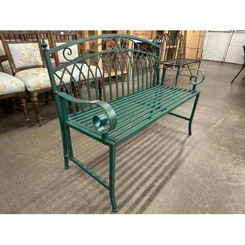 A green metal decorative garden bench
