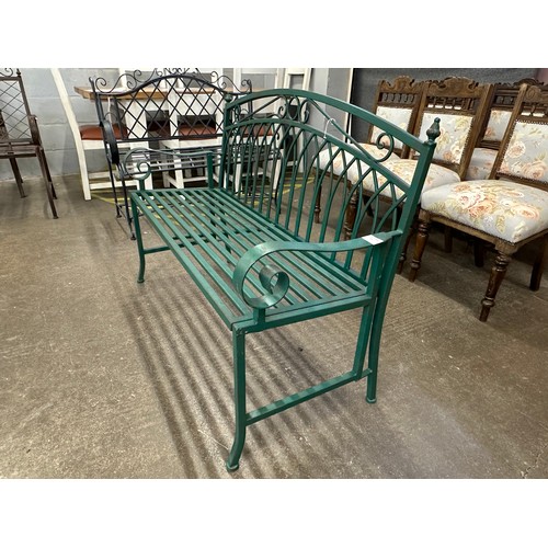 A green metal decorative garden bench