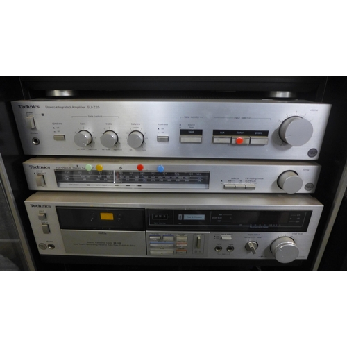 A quantity of Technics stereo separates in a wooden display cabinet ...