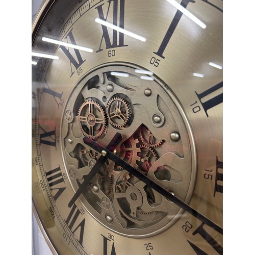 A gold effect circular moving gear clock