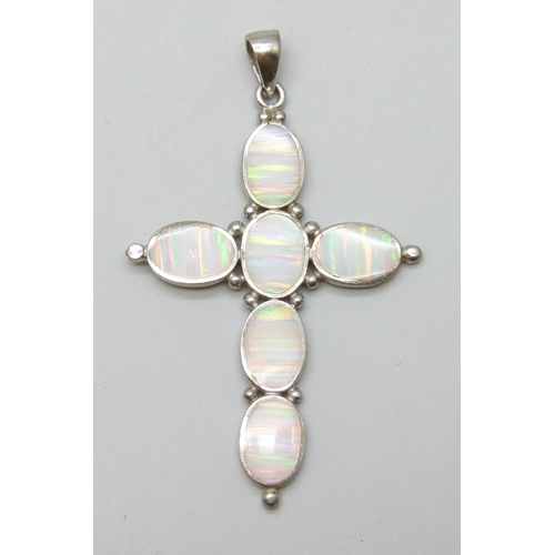 A silver cross design necklace pendant set with simulated opal panels ...