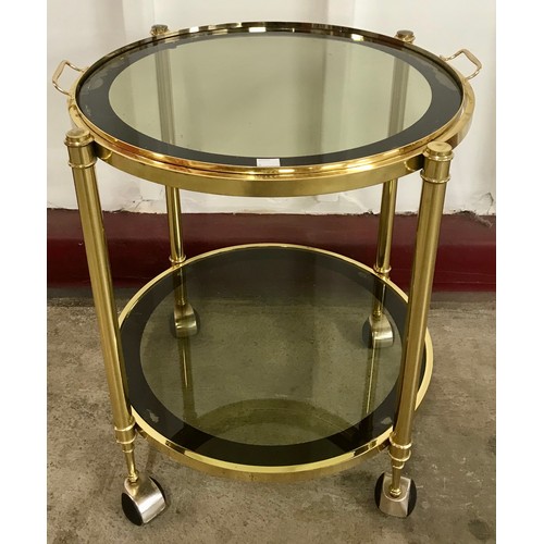 An Italian gilt and smoked glass two tier circular cocktail trolley