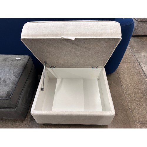 An ivory fabric upholstered storage footstool