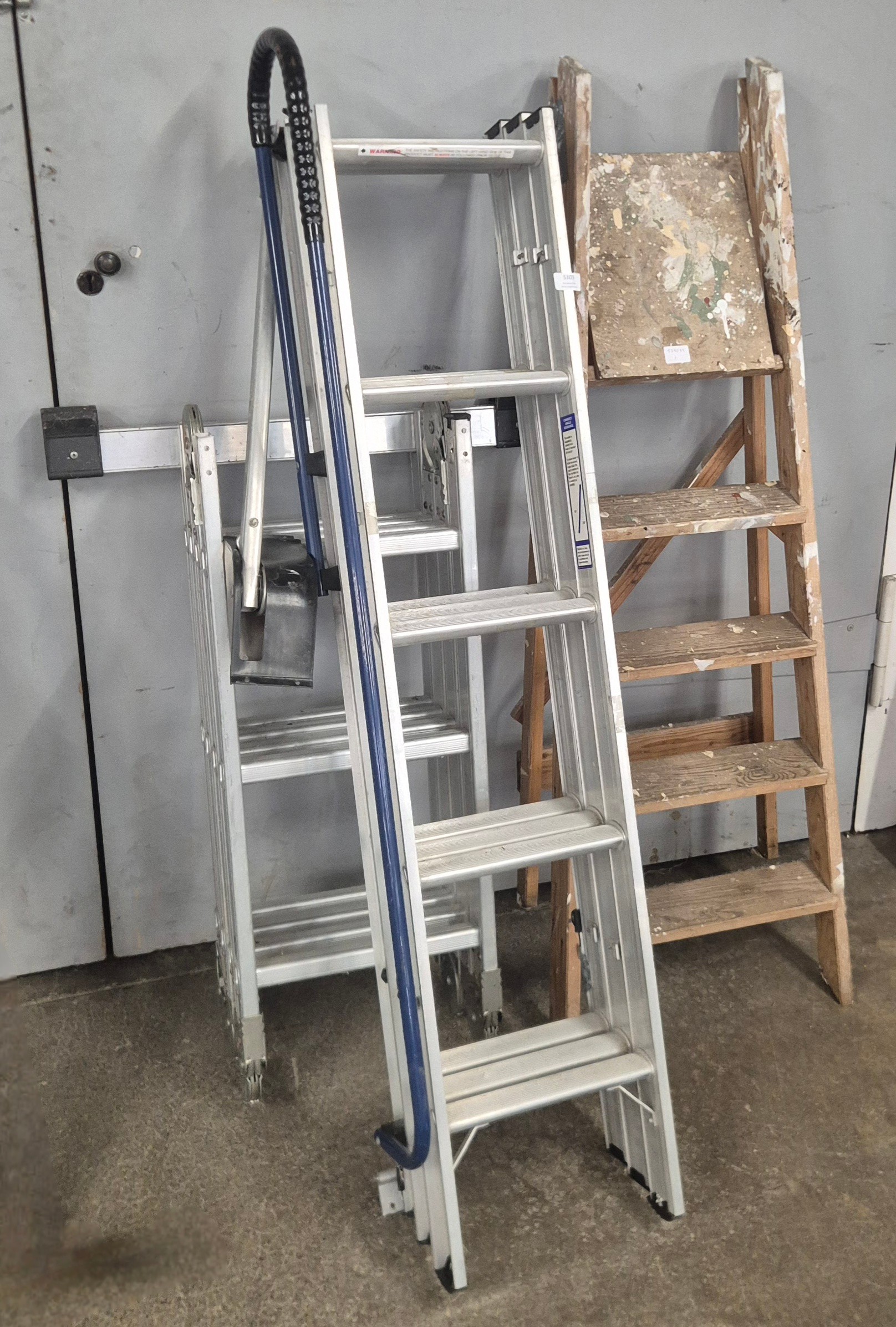 A 5 rung wooden step ladder, a 5 rung aluminum triple extending ladder ...