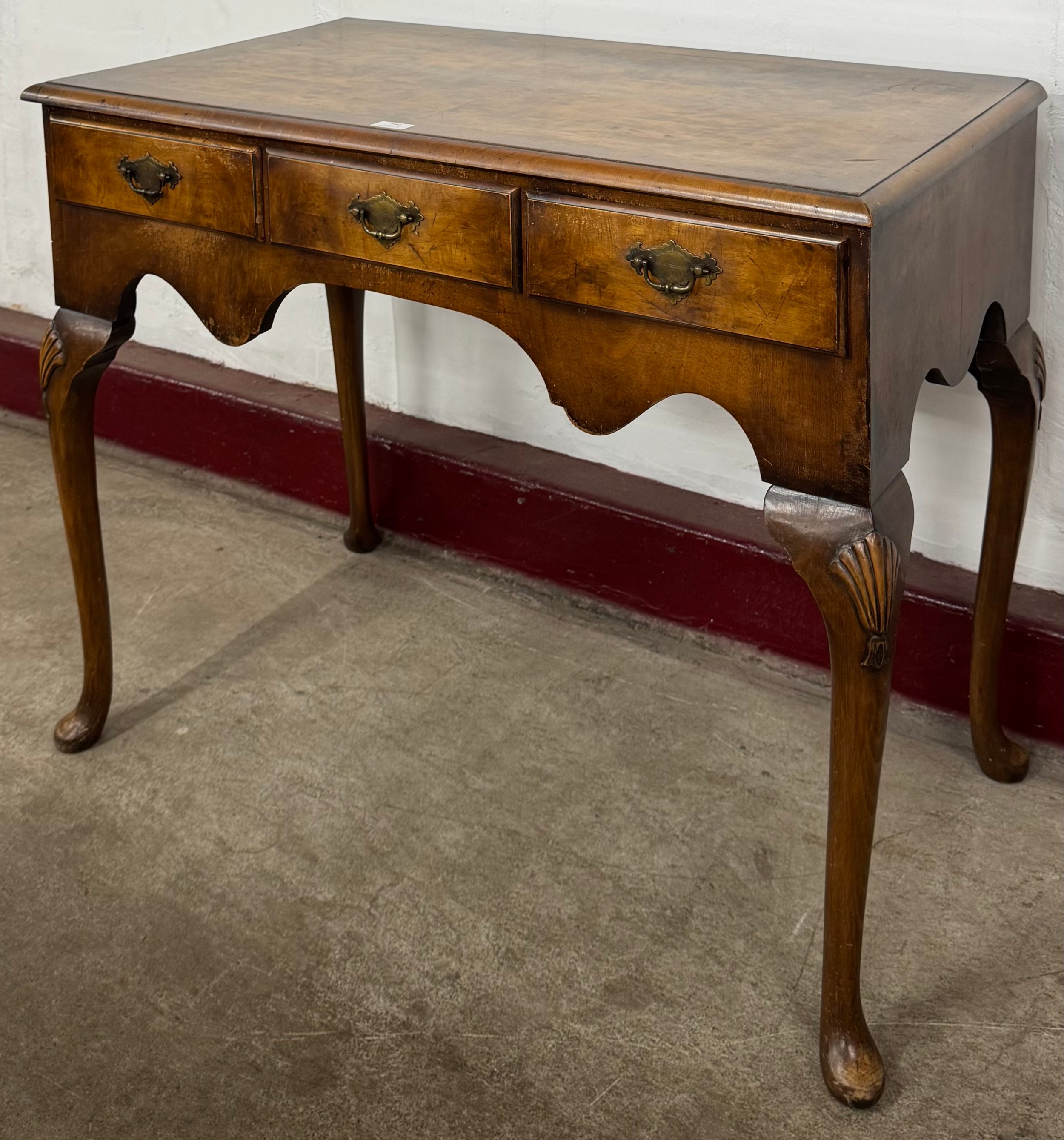 A Queen Anne style walnut three drawer side table