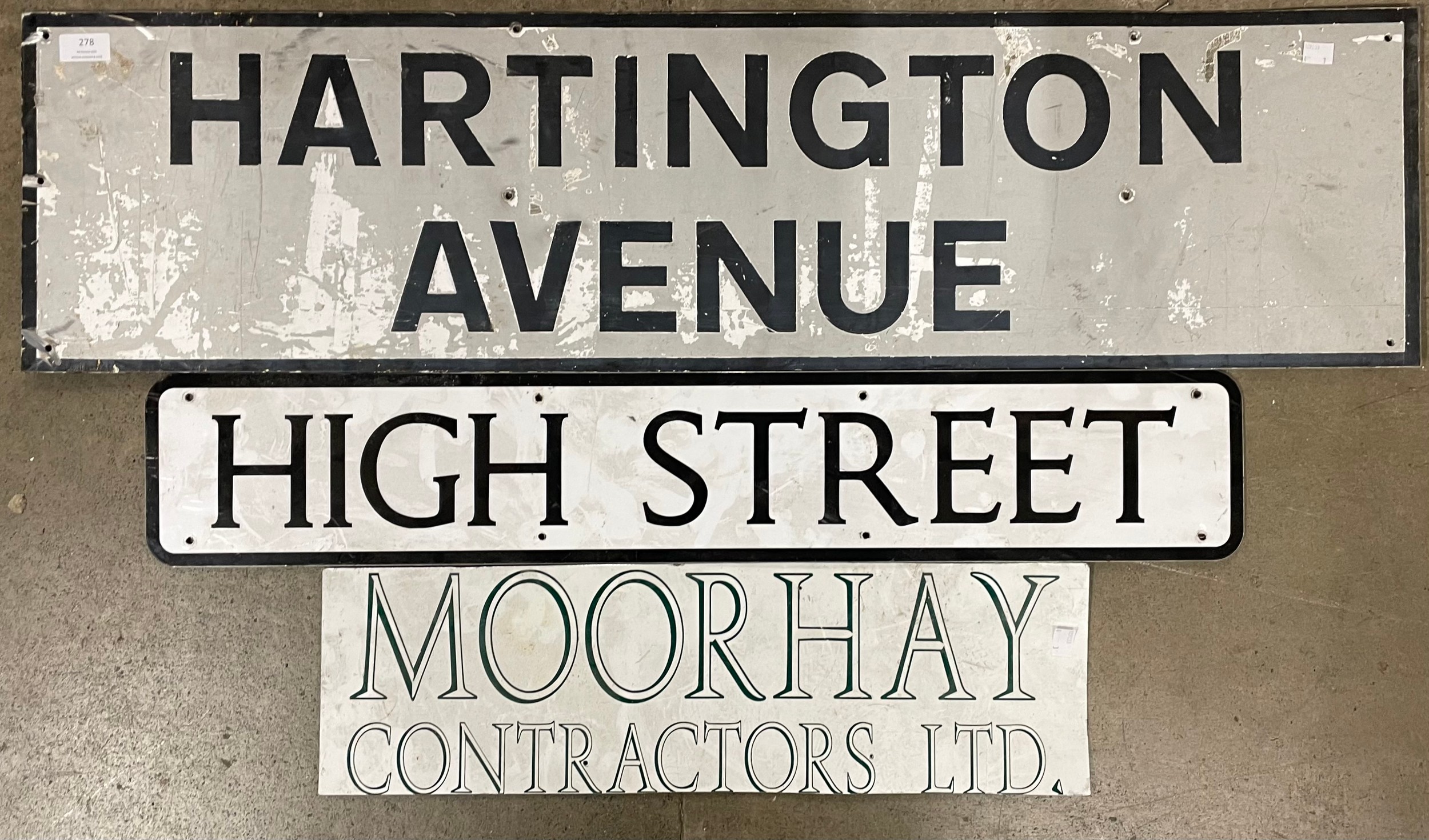 Two street signs and an advertising sign
