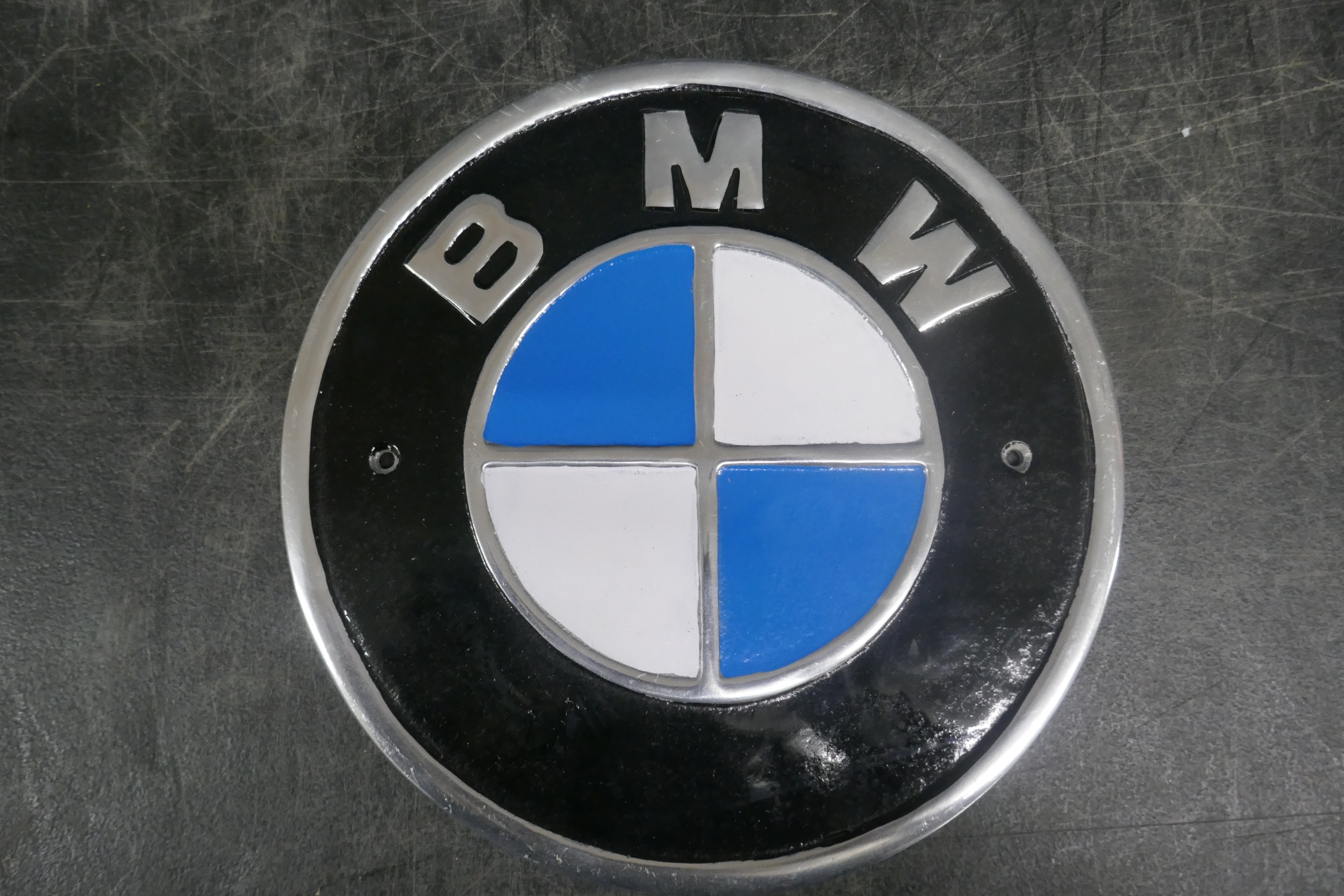 A painted aluminium BMW wall plaque