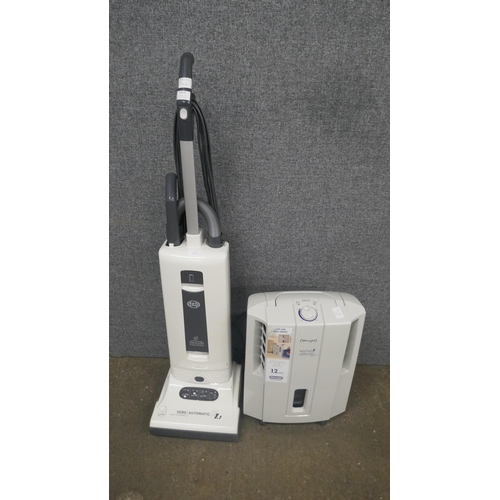 A Sebo Automatic X1.1 upright vacuum cleaner and a Tascrugo Delonghi ...