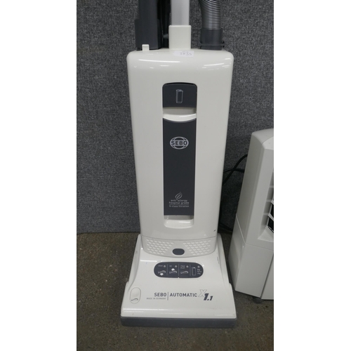 A Sebo Automatic X1.1 upright vacuum cleaner and a Tascrugo Delonghi ...