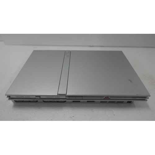 A limited edition satin silver PlayStation 2 slim games console with a ...