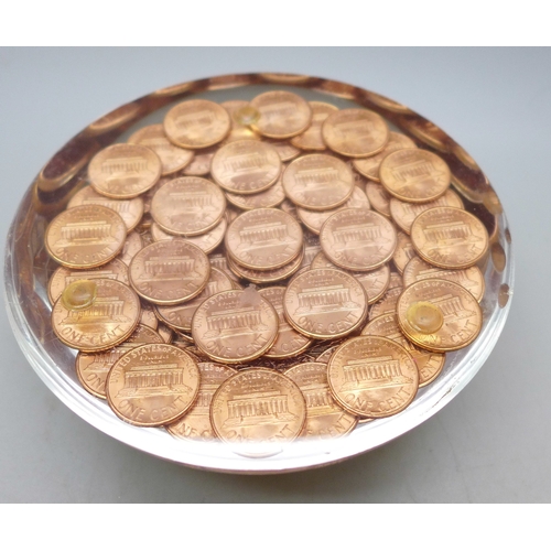 A novelty paperweight set with one hundred US one cent coins