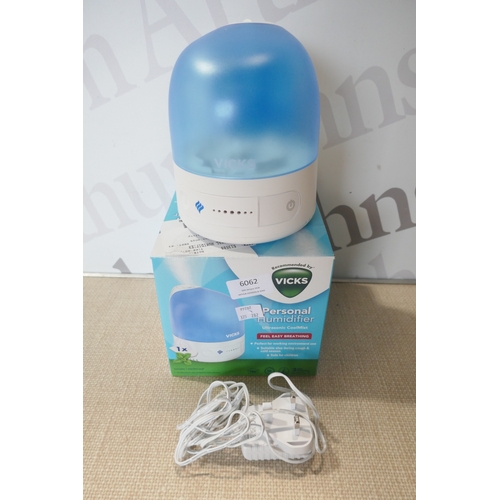 A digital LED clock with temperature and a Vicks personal humidifier ...