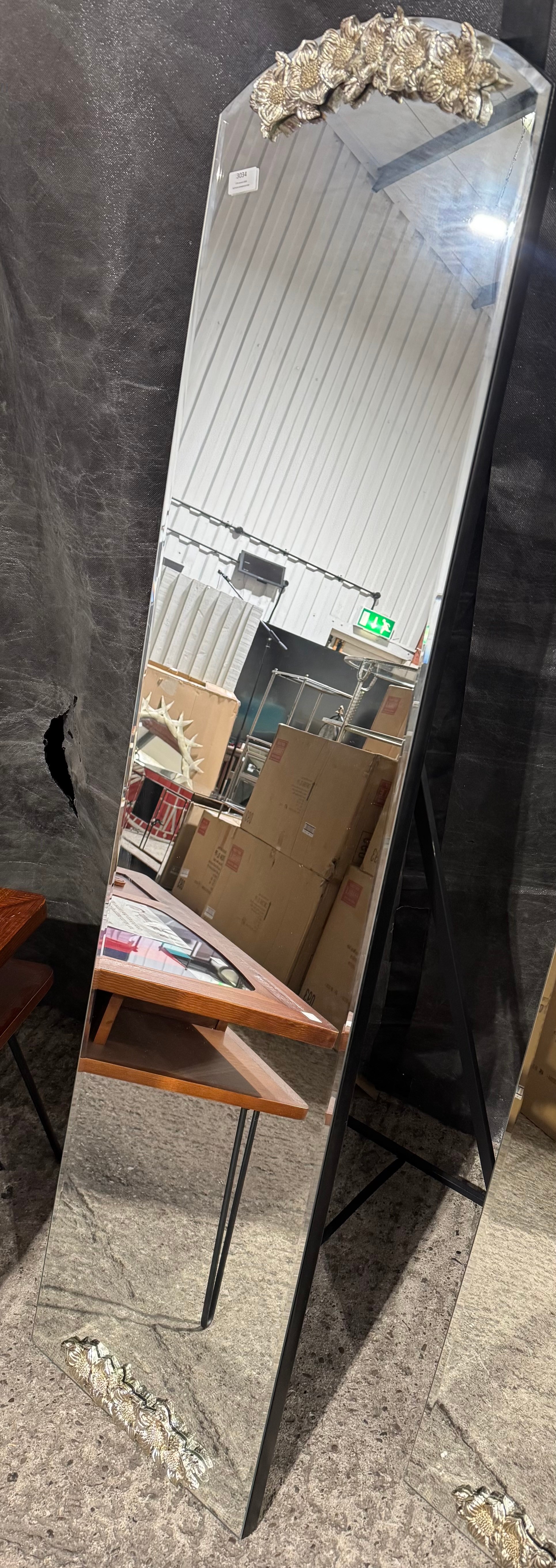 A bevelled edge arched mirror with floral design top and bottom