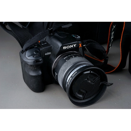 A collection of photographic equipment, including a Sony Alpha 200 ...