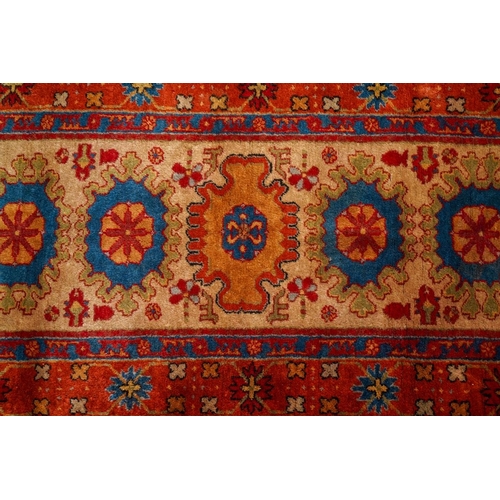 A 20th century Turkish woollen rug, red, blue and beige ground with ...
