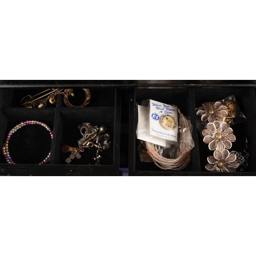 A collection of costume jewellery in a very large black jewellery box ...