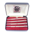 A boxed set of 4 silver and enamel bridge pencils, marked Sterling ...