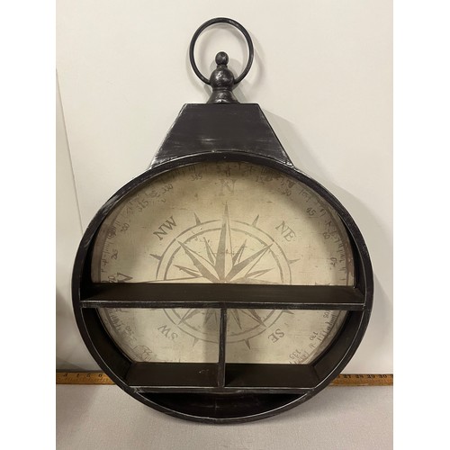 Metal compass shaped wall shelf.