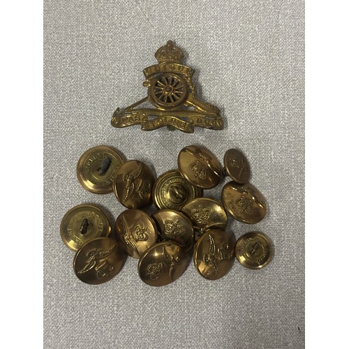 Selection of military buttons along with caps badge.