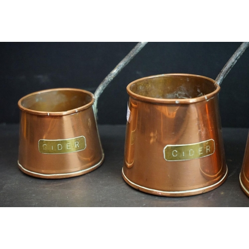 Set of three graduating copper cider measures with iron handles