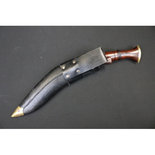 A Nepalese Kukuri knife with fullered steel blade, wooden grip and ...