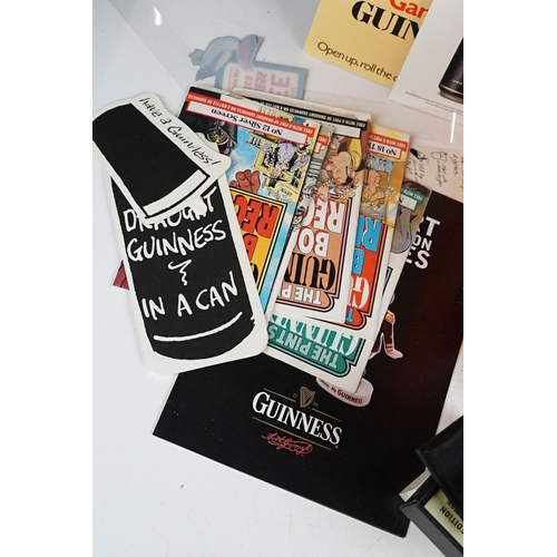 A mixed group of Guinness collectables to include badges, beer mats ...