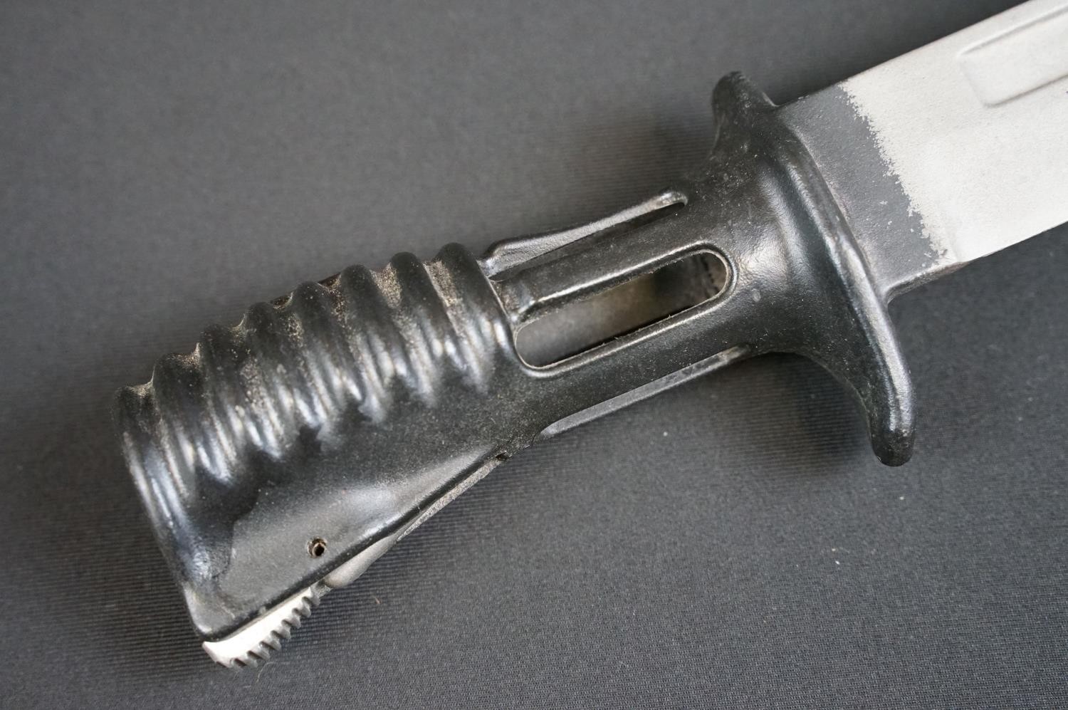 A Contemporary socket mount bayonet housed within canvas camouflage sheath.