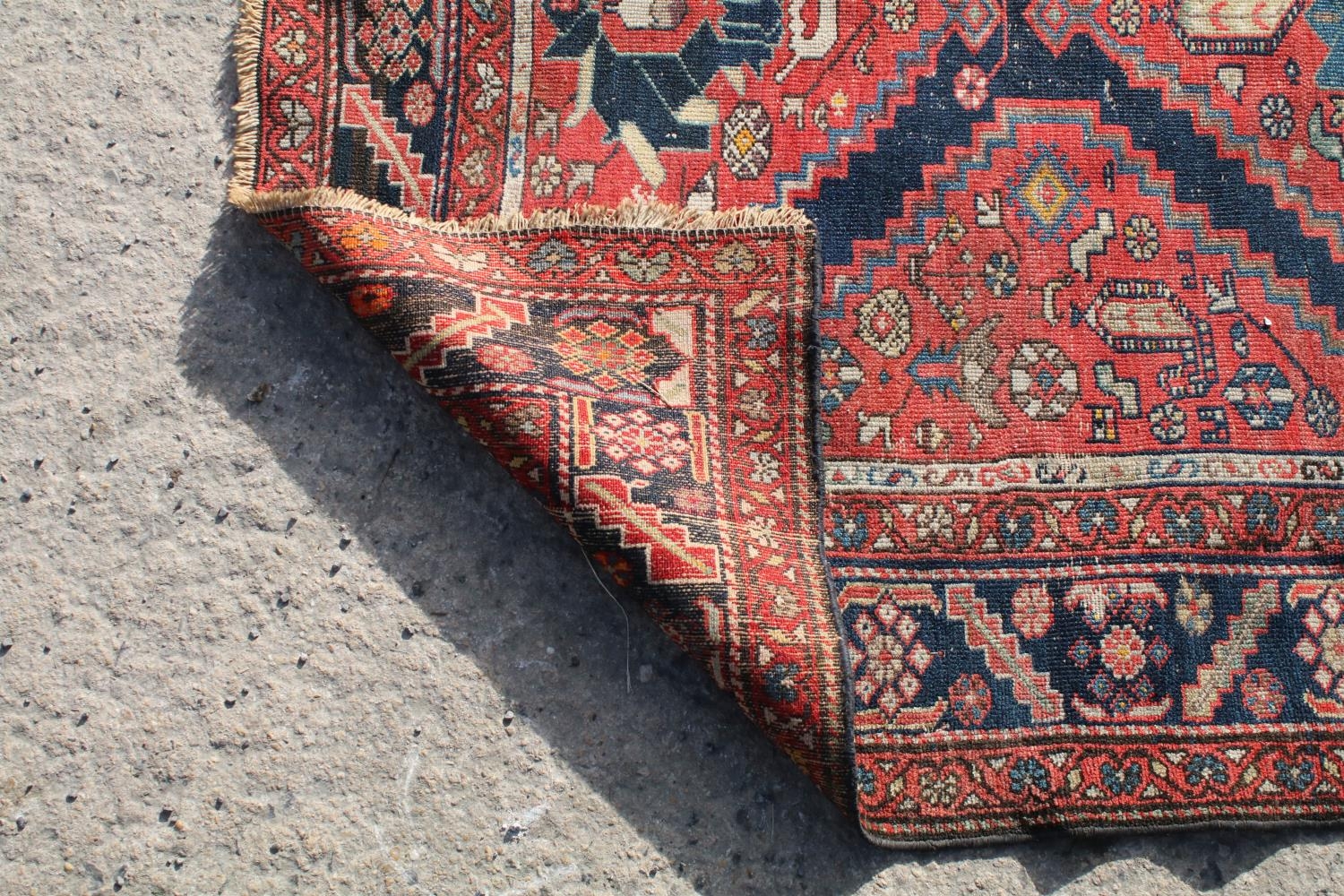Middle Eastern red ground rug, with central medallion and two half medallions, 197cm x 132cm