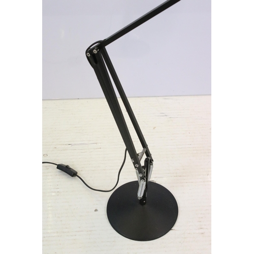 Anglepoise lamp having a round black base with mechanical arm and ...