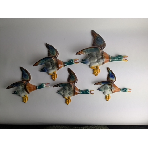 A set of five vintage ceramic flying duck wall plaques, some with ...