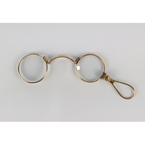 A pair of gold mounted folding lorgnettes with a loop form handle ...