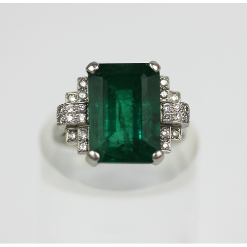 An emerald and diamond ring claw set with the rectangular emerald cut ...