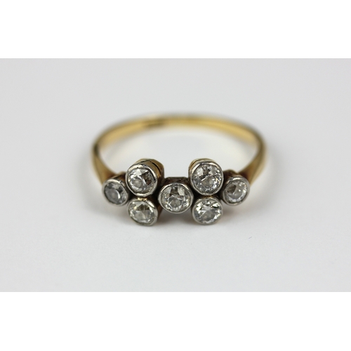 A gold and diamond ring collet set with seven old cut diamonds detailed ...