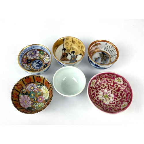 A group of six Japanese porcelain sake cups various designs to include ...