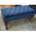 A blue velour button-upholstered footstool with four turned oak legs ...