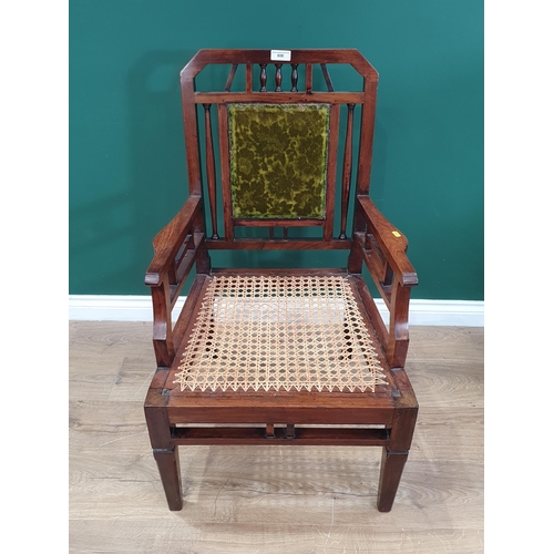 A walnut framed open Elbow Chair with cane seat
