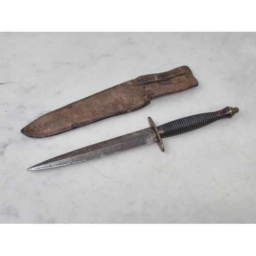 A Fairbairn Sykes 3rd Pattern Fighting Knife in associated leather sheath
