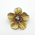 A gold metal Enamel Brooch depicting a hellebore with three single-cut ...
