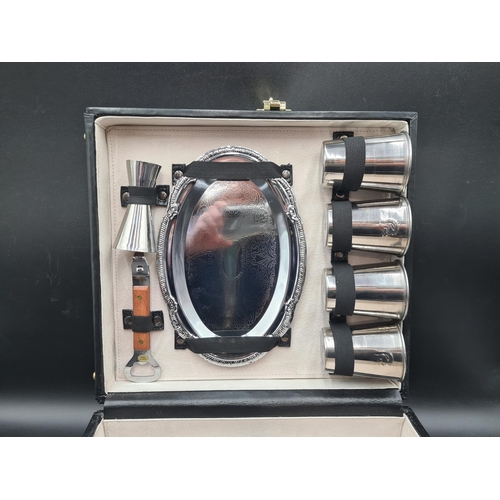 A Travelling Drinks Case containing double ended measure, four beakers ...