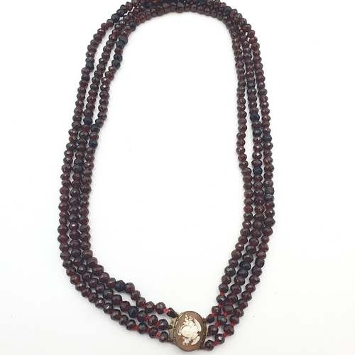 A triple strand faceted Garnet Bead Necklace on yellow metal clasp set ...