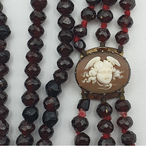 A triple strand faceted Garnet Bead Necklace on yellow metal clasp set ...