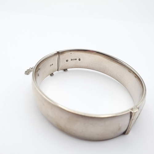 A hinged Silver Bangle engraved with thistles with gold detailing ...