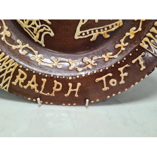 A slipware Charger decorated with Figure and Flowers and bearing the ...