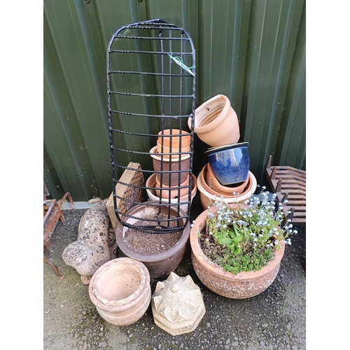 A selection of terracotta and pottery flower pots, a metal hay rack and ...